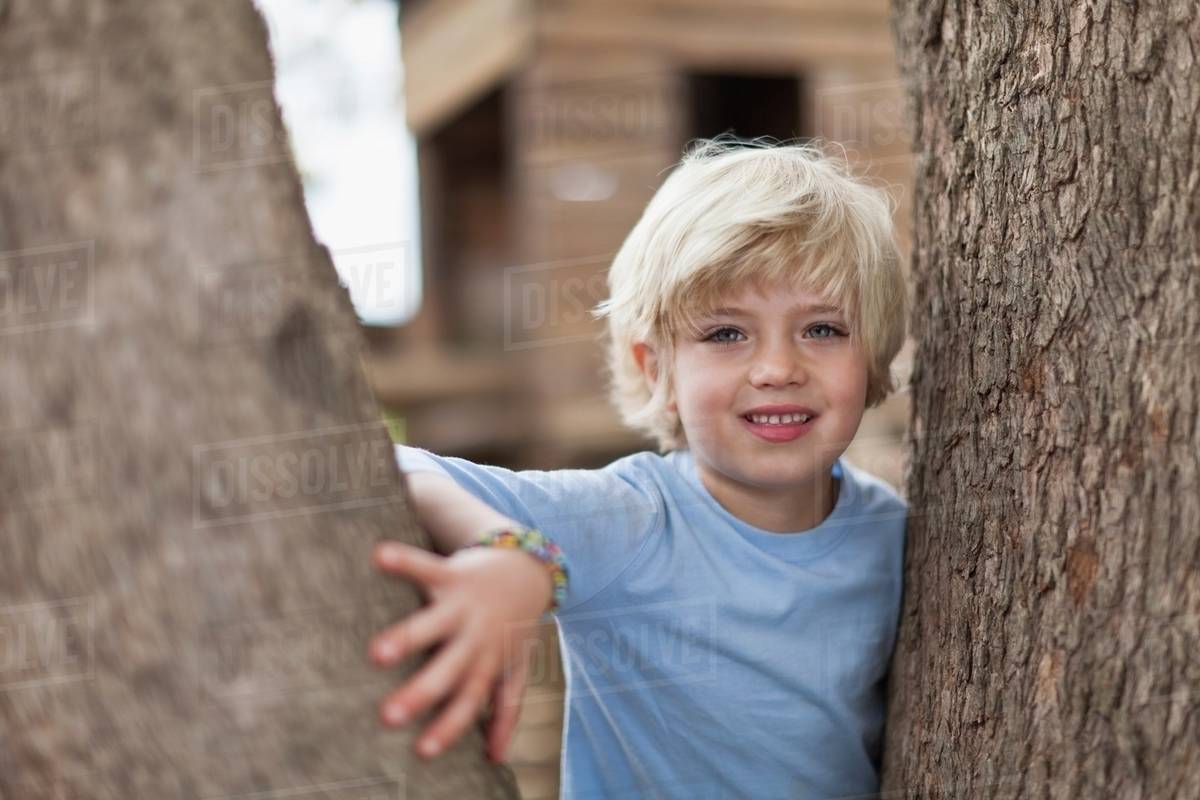 Boy playing in tree outdoors - Royalty-free Stock Photo | Dissolve