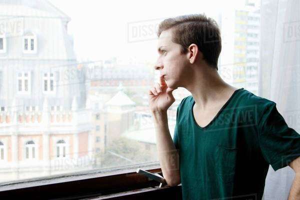 Man looking out window - Royalty-free Stock Photo | Dissolve