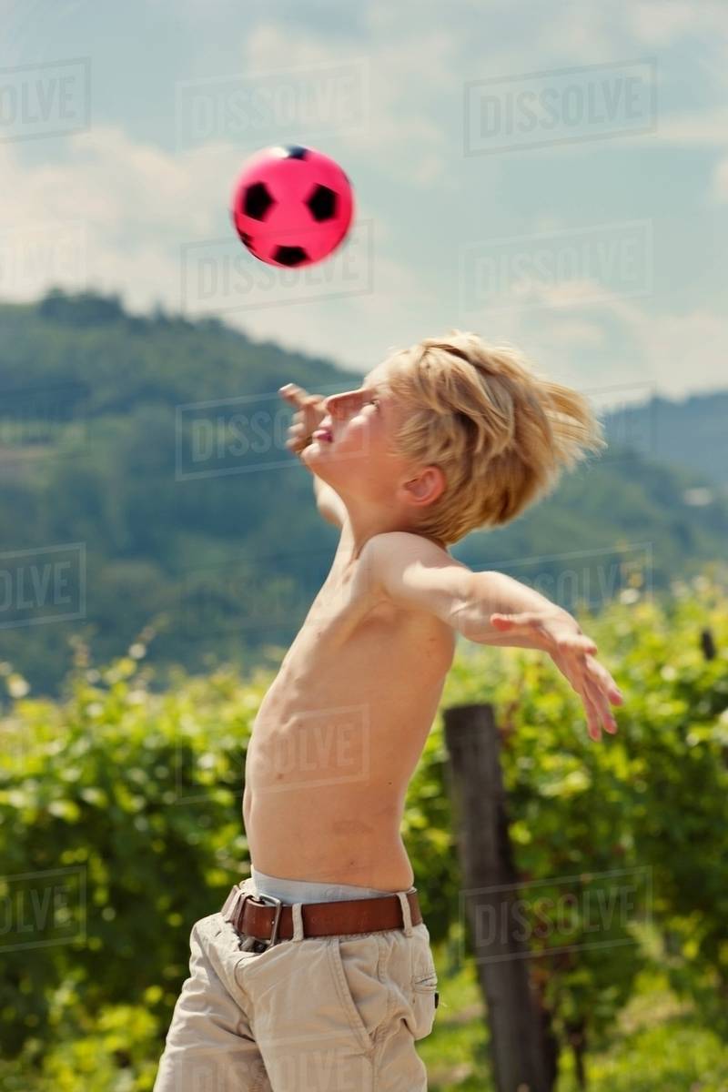 Boy playing with soccer ball outdoors - Royalty-free Stock Photo | Dissolve