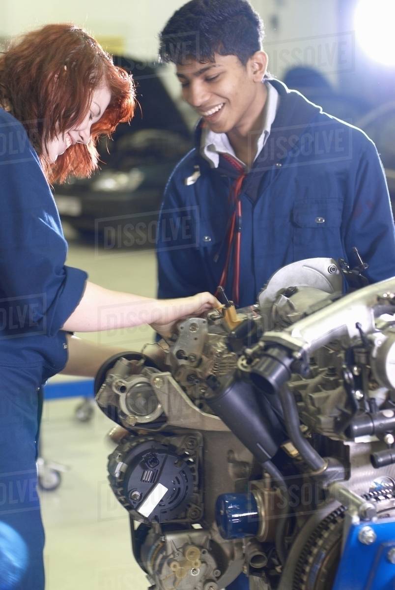 Students working on car engine - Royalty-free Stock Photo | Dissolve