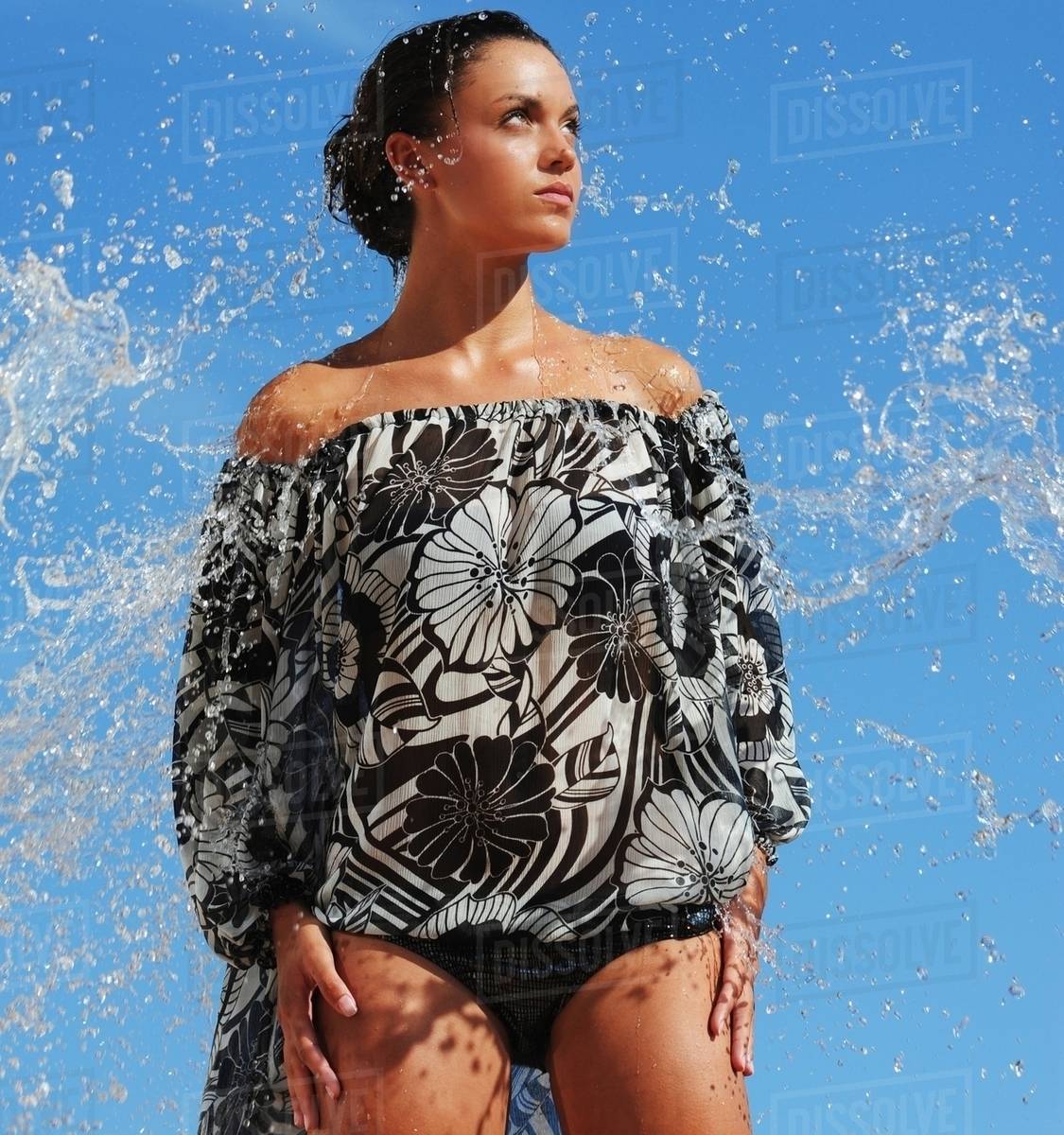 Water splashing on woman outdoors - Stock Photo - Dissolve