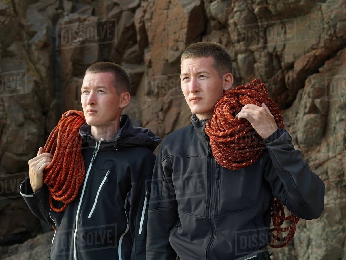 Men carrying loops of rope on beach - Royalty-free Stock Photo | Dissolve