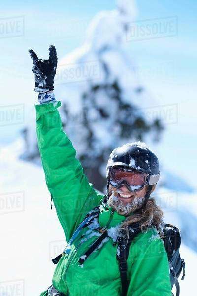 Skier making hand gesture in snow - Stock Photo - Dissolve