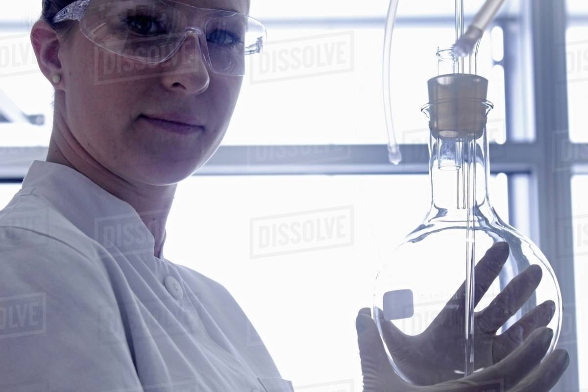 Scientist holding beaker in lab - Royalty-free Stock Photo | Dissolve