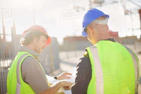 Construction workers talking on site - Royalty-free Stock Photo | Dissolve
