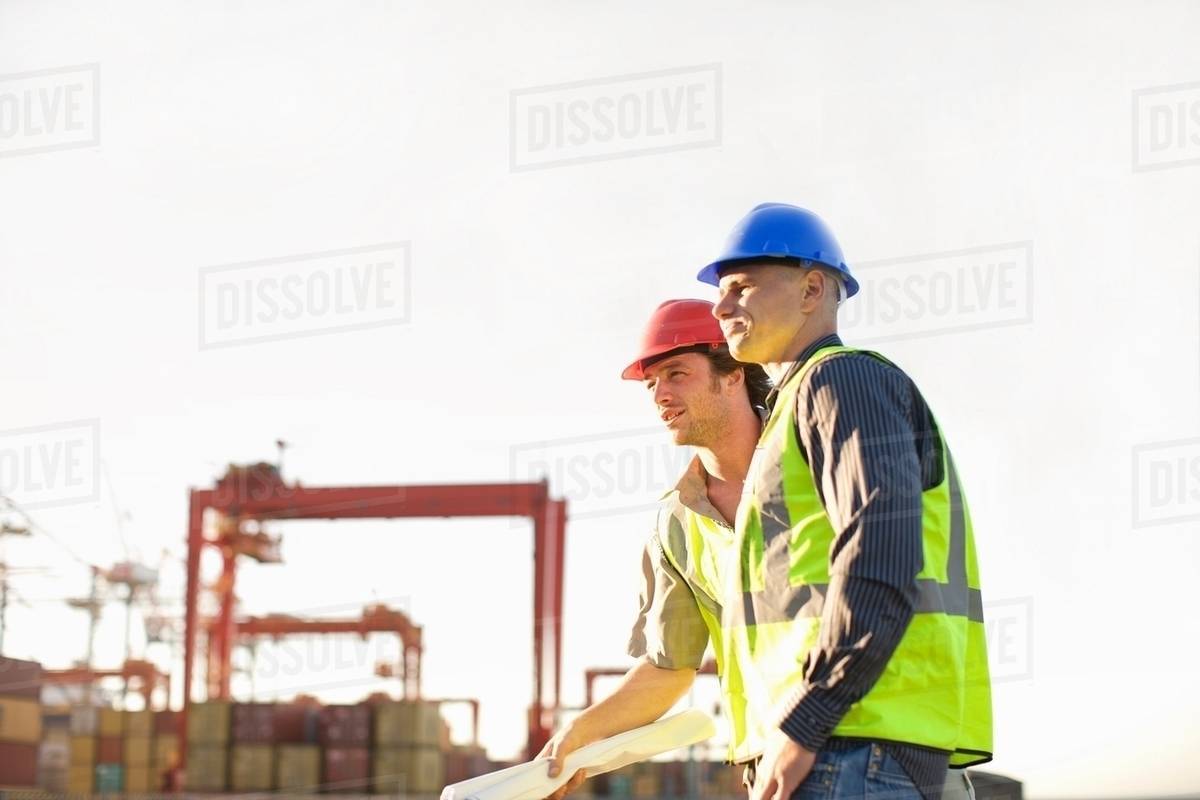Construction workers talking on site - Stock Photo - Dissolve