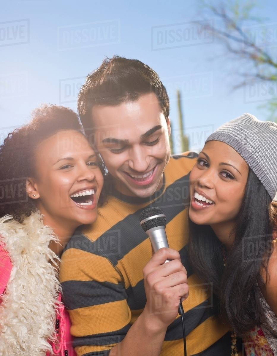 Friends singing together outdoors - Stock Photo - Dissolve