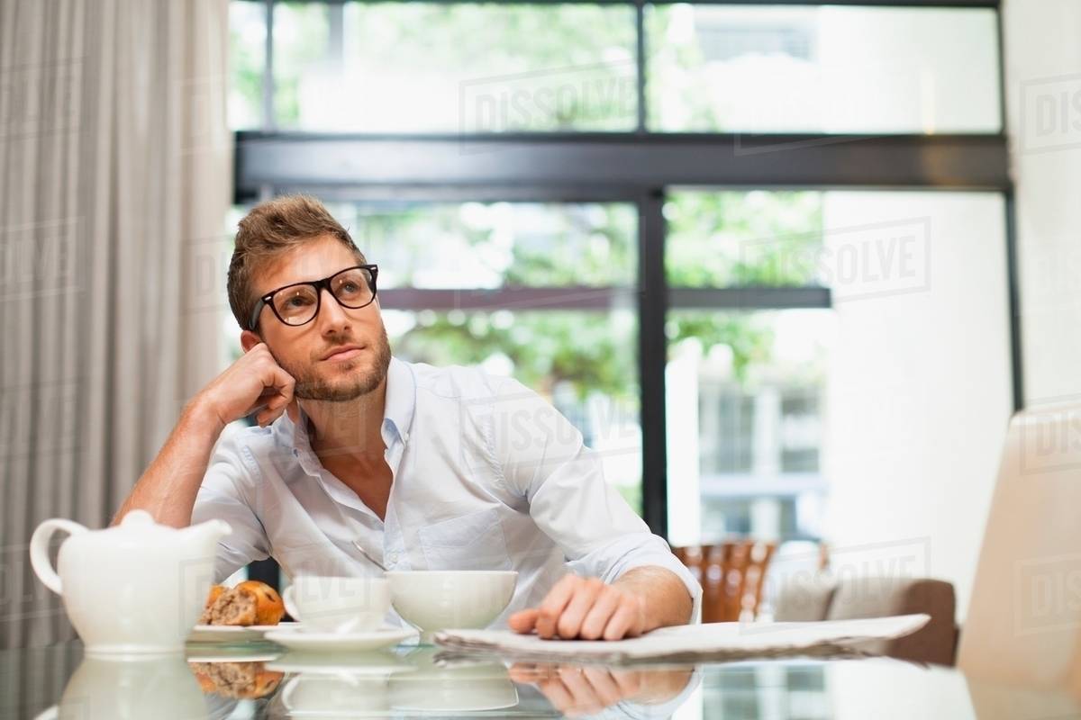 Smiling man sitting at breakfast - Stock Photo - Dissolve