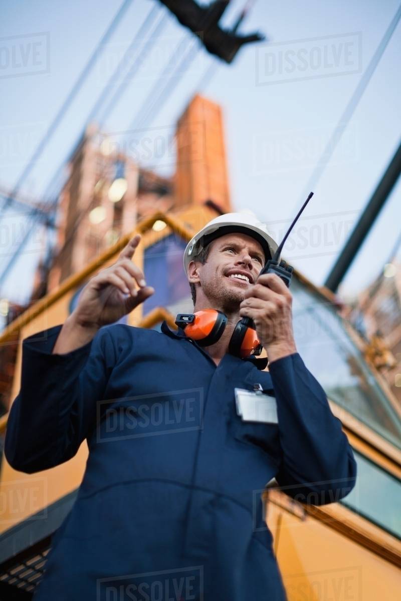 Worker using walkie talkie on site - Royalty-free Stock Photo | Dissolve