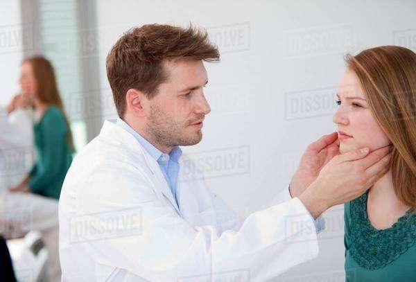 Doctor examining woman in office - Royalty-free Stock Photo | Dissolve