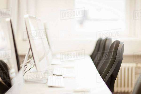Empty computer desks in office - Stock Photo - Dissolve