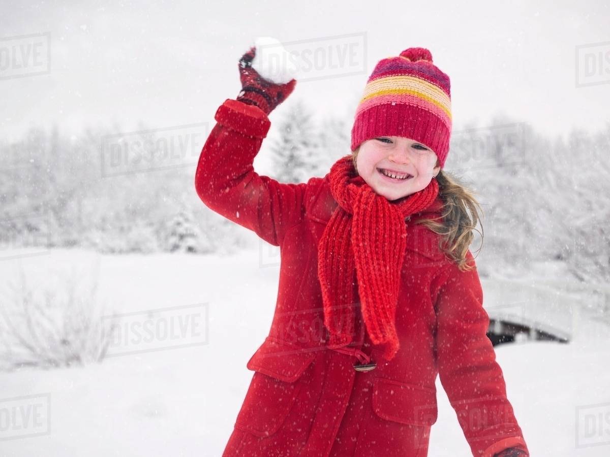 Smiling girl throwing snowball - Royalty-free Stock Photo | Dissolve