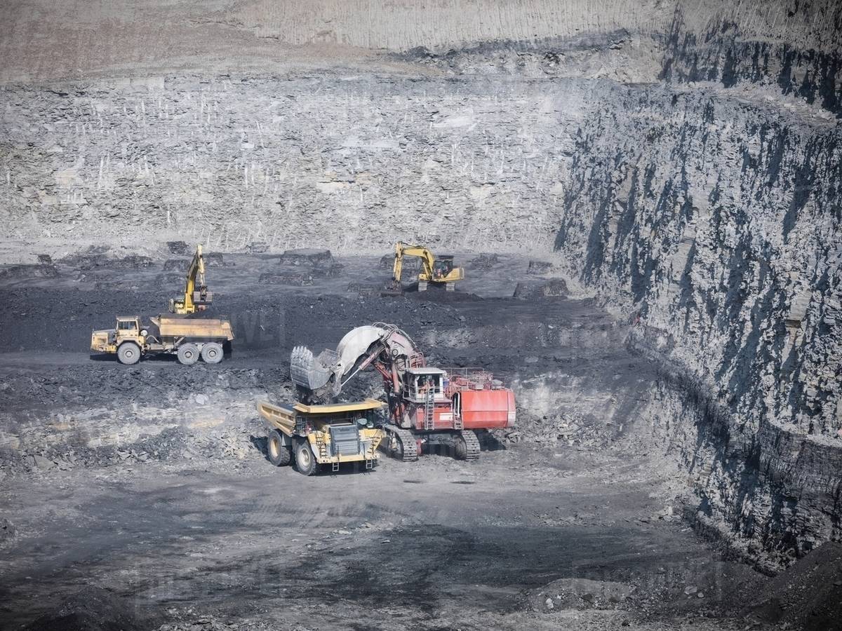 Digger loading coal into dumper truck in opencast coalmine - Stock ...