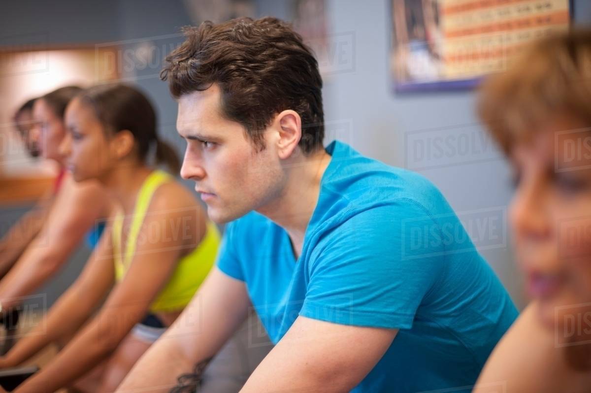 People using spin machines in gym - Stock Photo - Dissolve