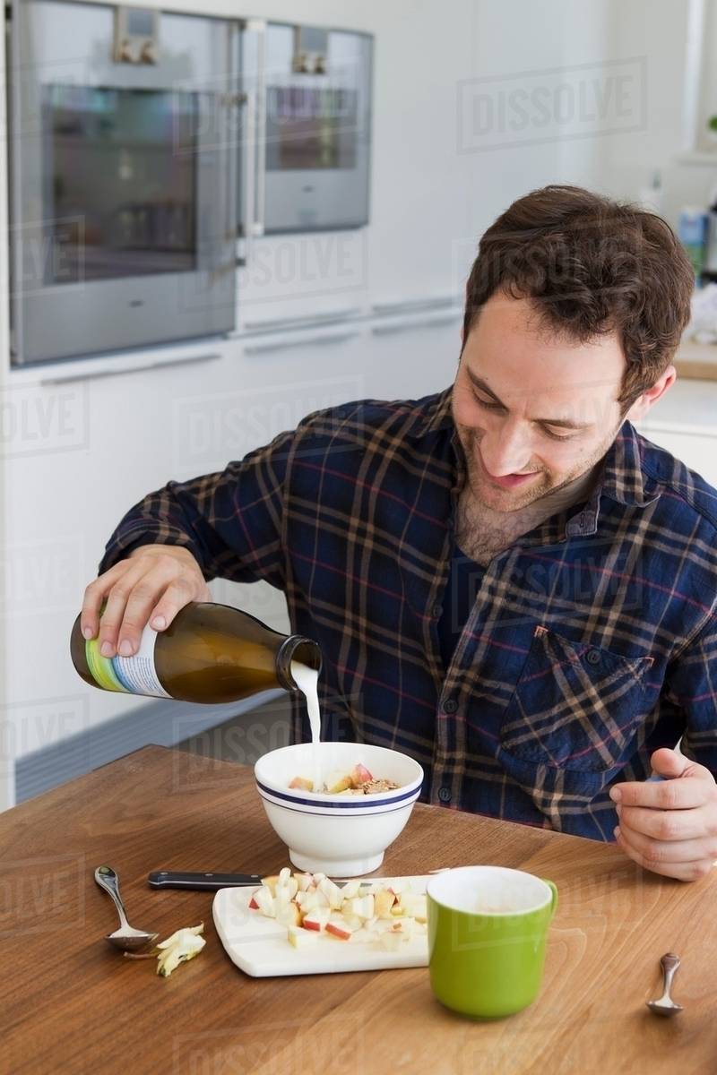 Man pouring milk for cereal - Royalty-free Stock Photo | Dissolve