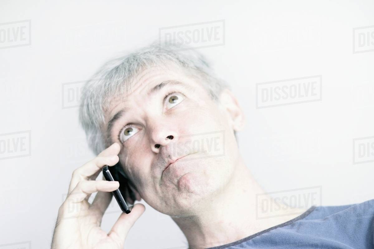 Frowning man talking on cell phone - Royalty-free Stock Photo | Dissolve