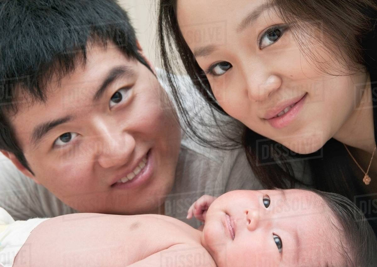 Close up of parents smiling with baby - Stock Photo - Dissolve