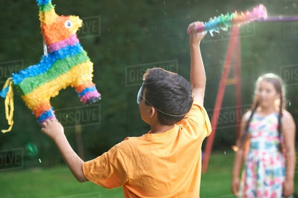 Children playing pinata in garden - Royalty-free Stock Photo | Dissolve