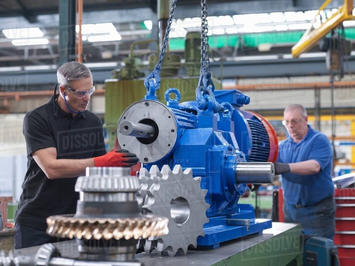 Engineers assembling industrial gearbox in engineering factory - Stock ...
