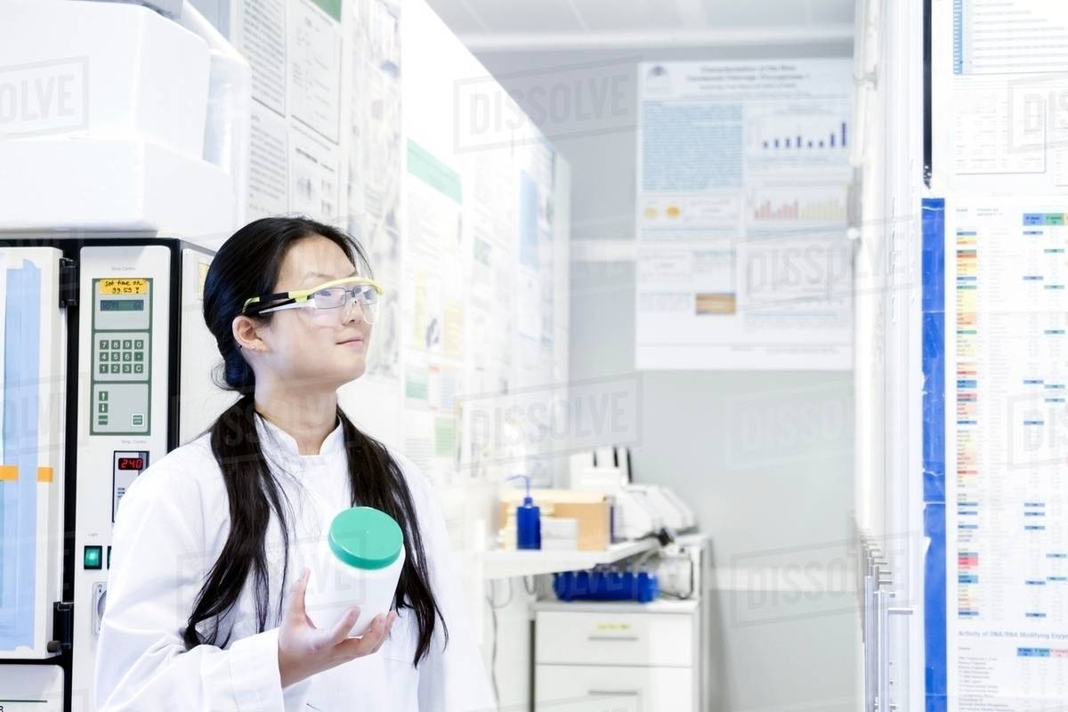 Female scientist holding specimen jar in laboratory - Royalty-free ...