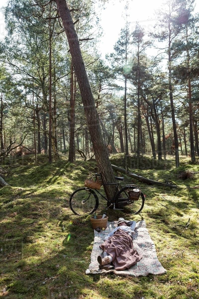 Mature female forager lying on blanket in forest - Royalty-free Stock ...