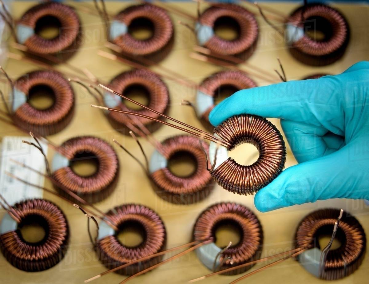 Worker holding Electromagnetic coils in electromagnetics factory, close ...