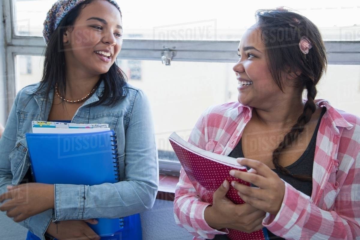Students standing by window, chatting - Royalty-free Stock Photo | Dissolve