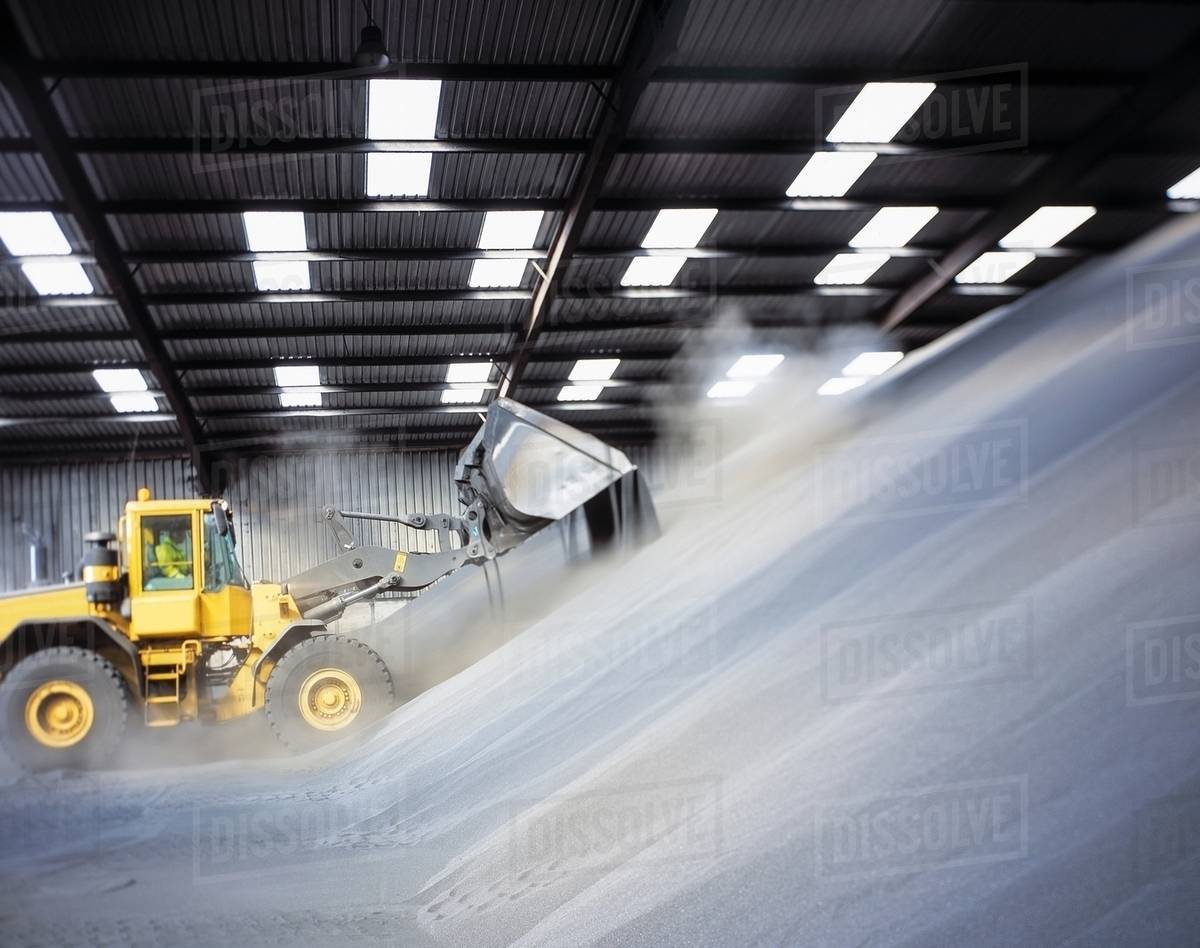 Digger loading bulk fertilizer in port - Stock Photo - Dissolve