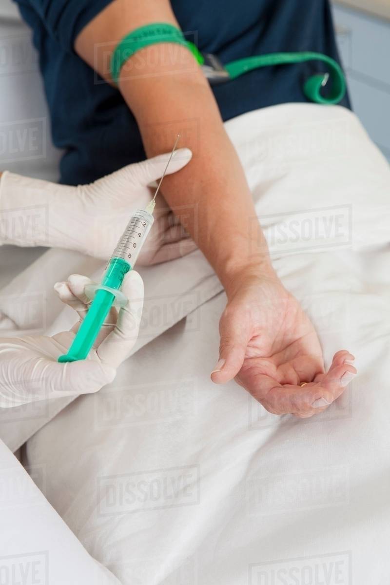 Close up of patients arm with injection - Stock Photo - Dissolve