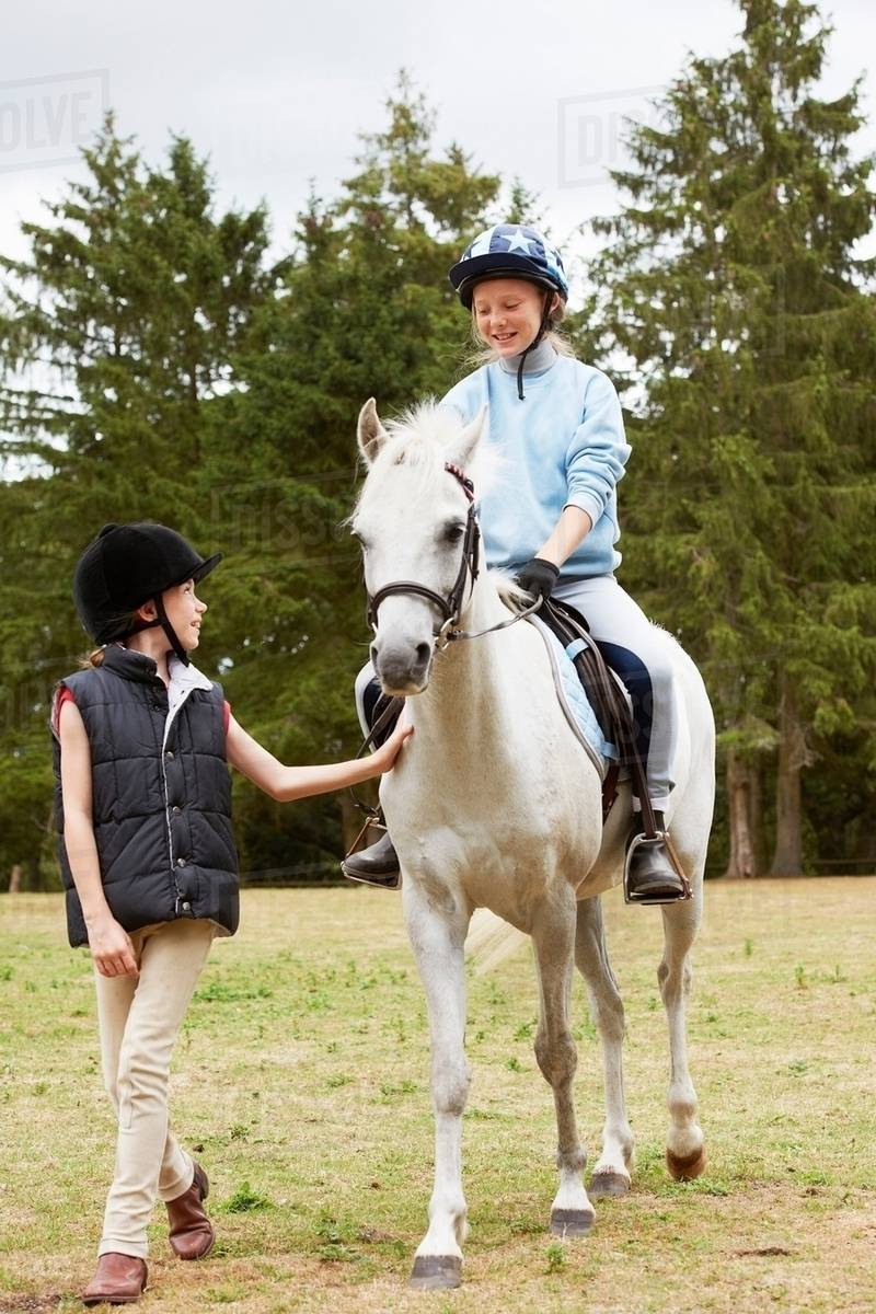 Girls riding a pony - Royalty-free Stock Photo | Dissolve