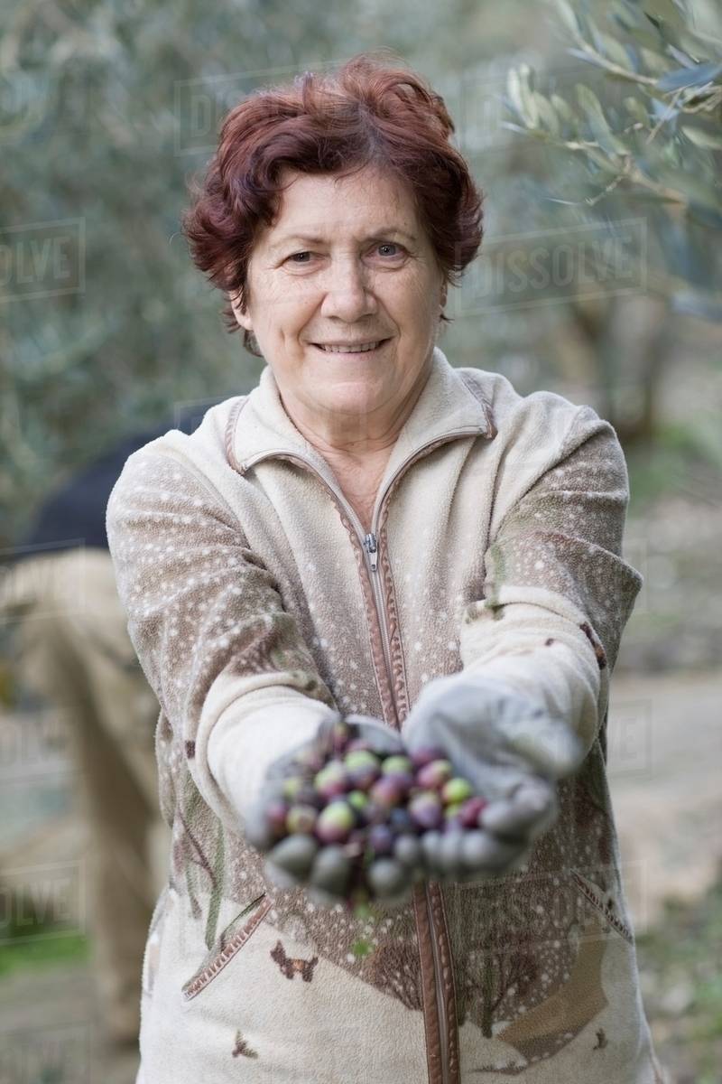 Older woman with olives - Stock Photo - Dissolve