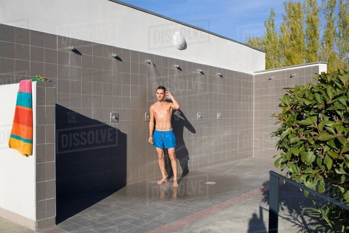 Young man in outdoor shower with swimsuit - Royalty-free Stock Photo ...