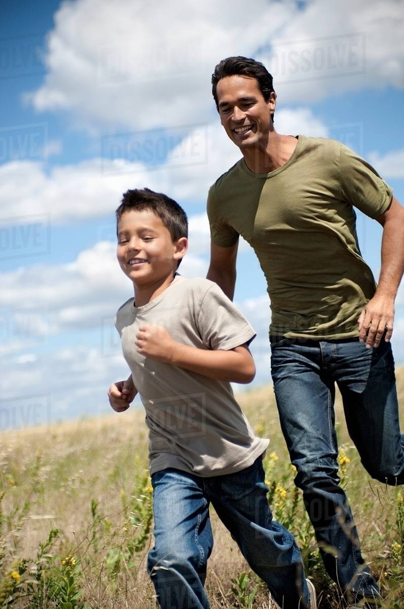 Father and son running through a field - Royalty-free Stock Photo ...