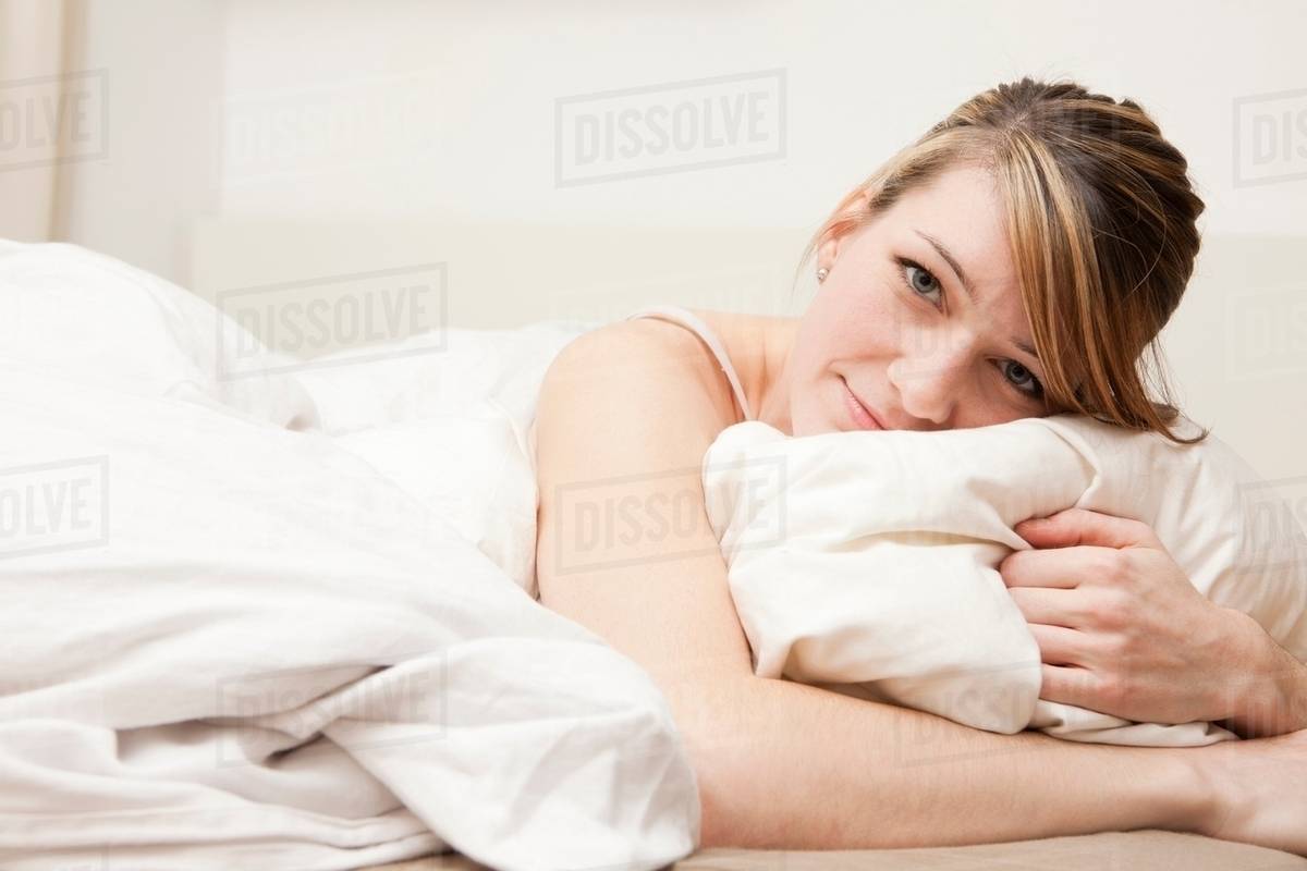 Portrait of young woman in bed - Royalty-free Stock Photo | Dissolve