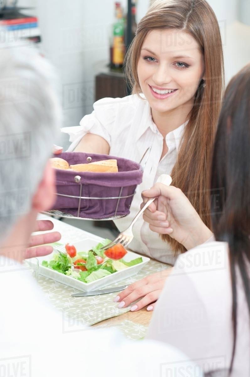 Passing the bread at lunch - Royalty-free Stock Photo | Dissolve