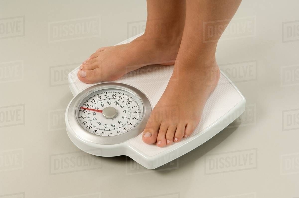 Female feet on scales - Royalty-free Stock Photo | Dissolve