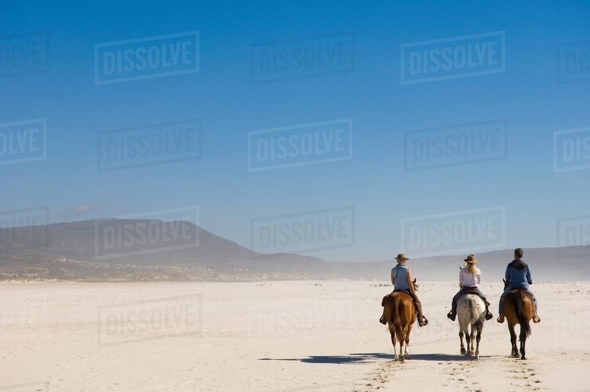 3 people riding horses on the beach - Royalty-free Stock Photo | Dissolve