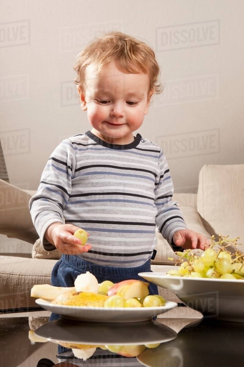 Little boy eating fruit - Royalty-free Stock Photo | Dissolve