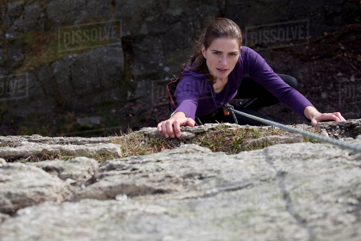 Woman abseiling with lake below - Royalty-free Stock Photo | Dissolve