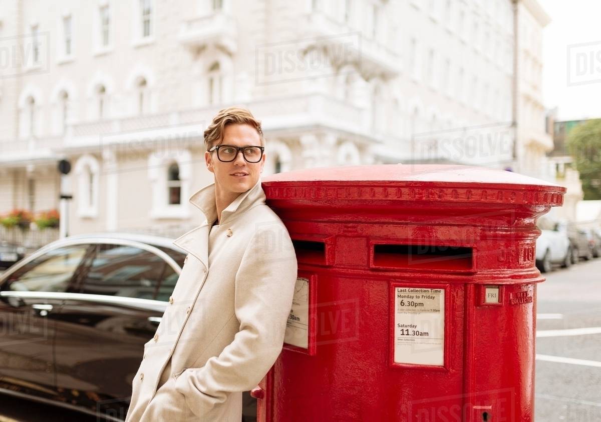 Stylish young man leaning against red post box, London, England, UK ...