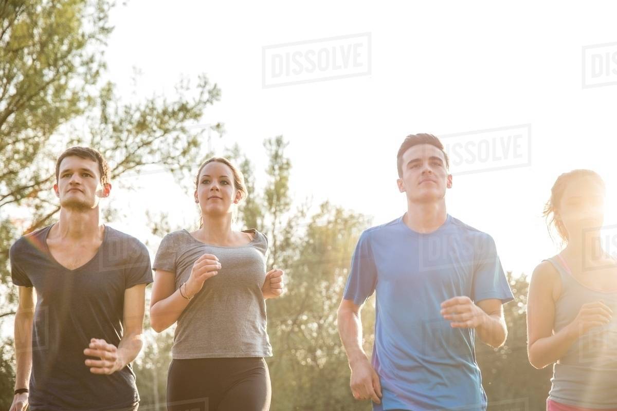Group of friends running outdoors in rural environment - Stock Photo ...