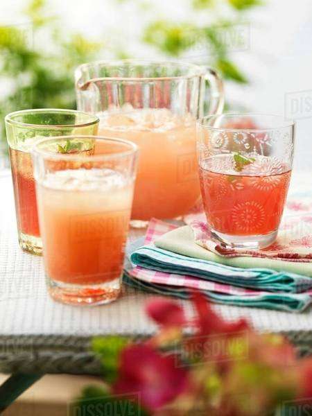 Glasses of fresh home made fruit drinks and ice - Stock Photo - Dissolve