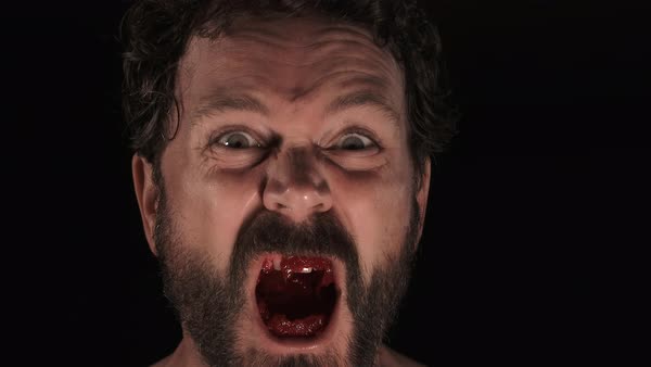 Evil and deranged man comes close up and scares with disgusting red ...