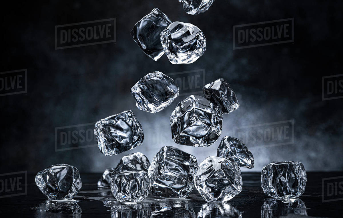Falling ice cubes and translucent crushed ice heap on black background ...