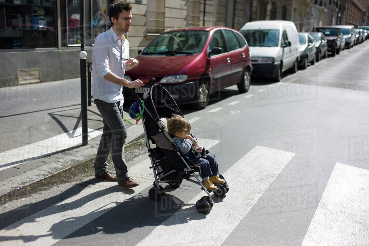 Father pushing toddler son in stroller - Royalty-free Stock Photo ...