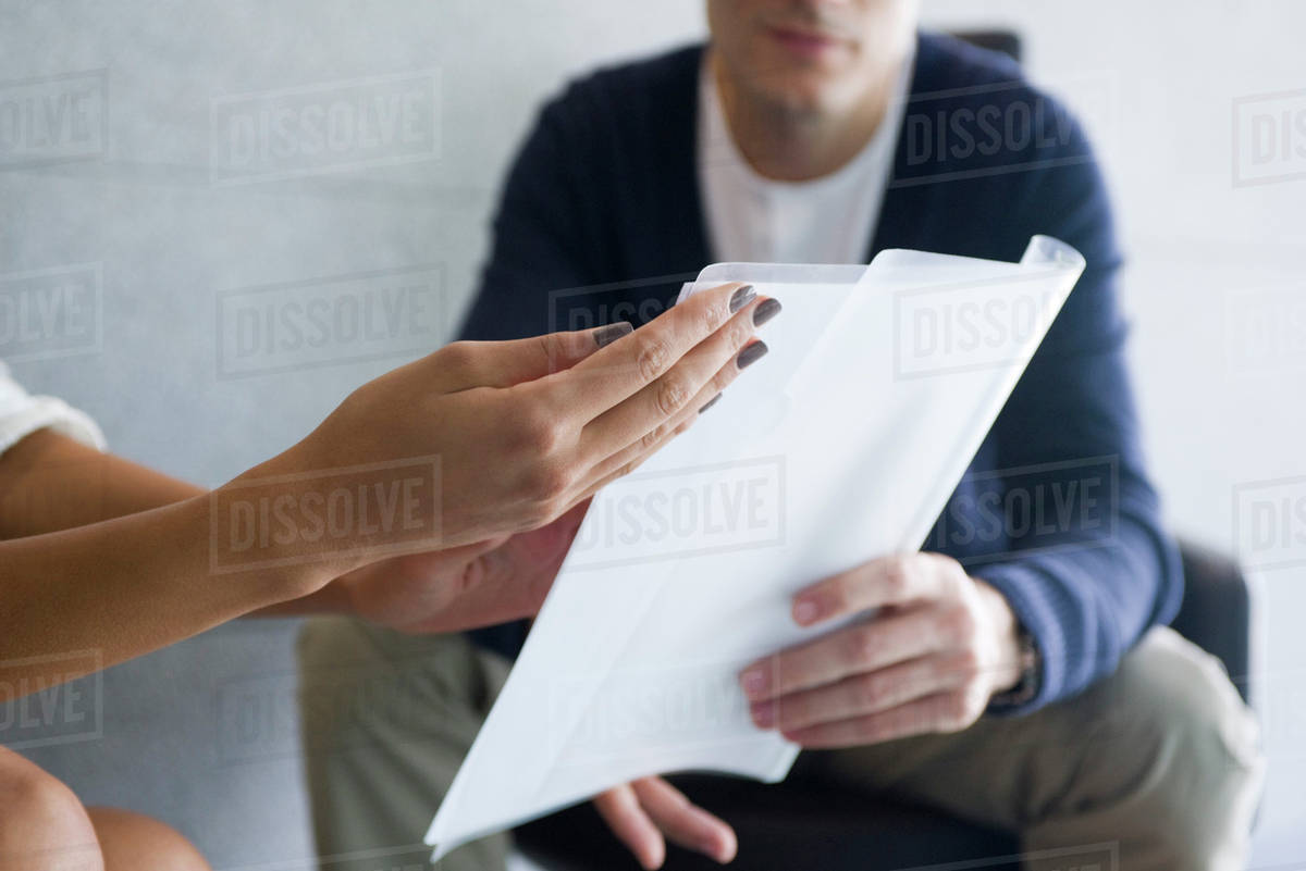 Woman's hand holding document - Stock Photo - Dissolve