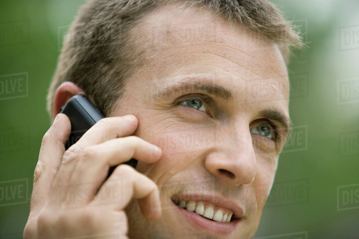 Man using cell phone outdoors - Royalty-free Stock Photo | Dissolve