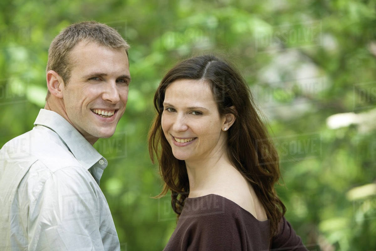 Couple smiling over shoulders at camera - Royalty-free Stock Photo ...