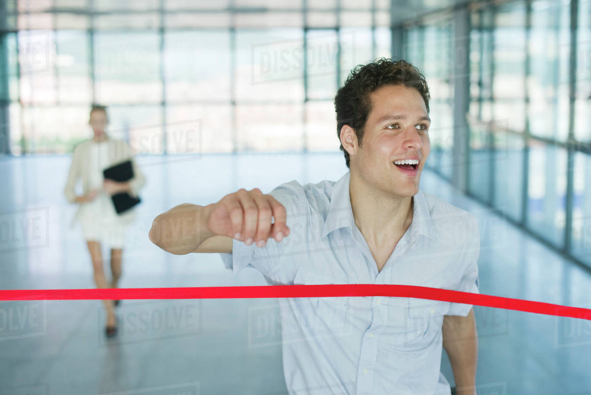 Businessman crossing finishing line - Stock Photo - Dissolve