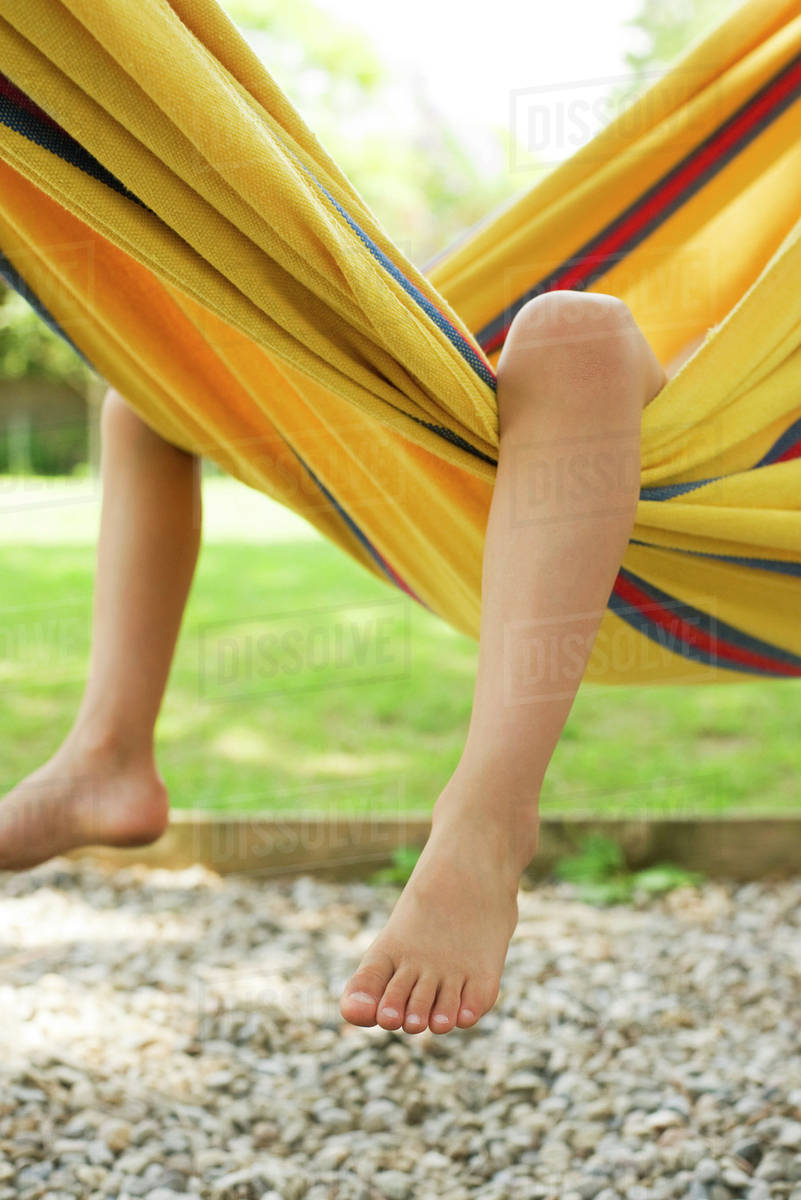 Child's legs dangling from hammock - Royalty-free Stock Photo | Dissolve